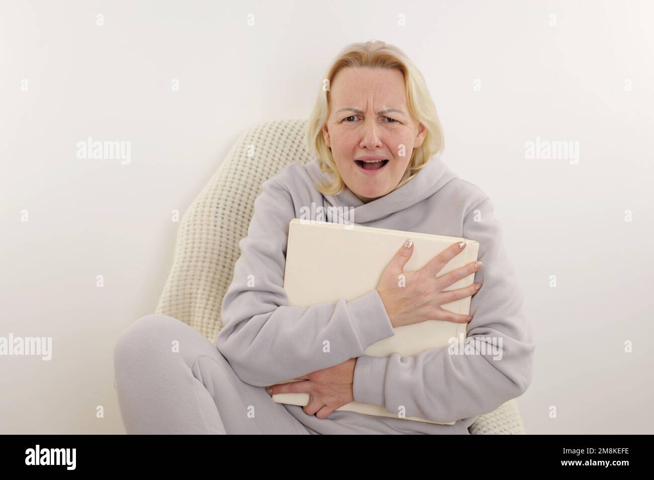 woman in a tracksuit is sitting on a white background, I am hugging a ...
