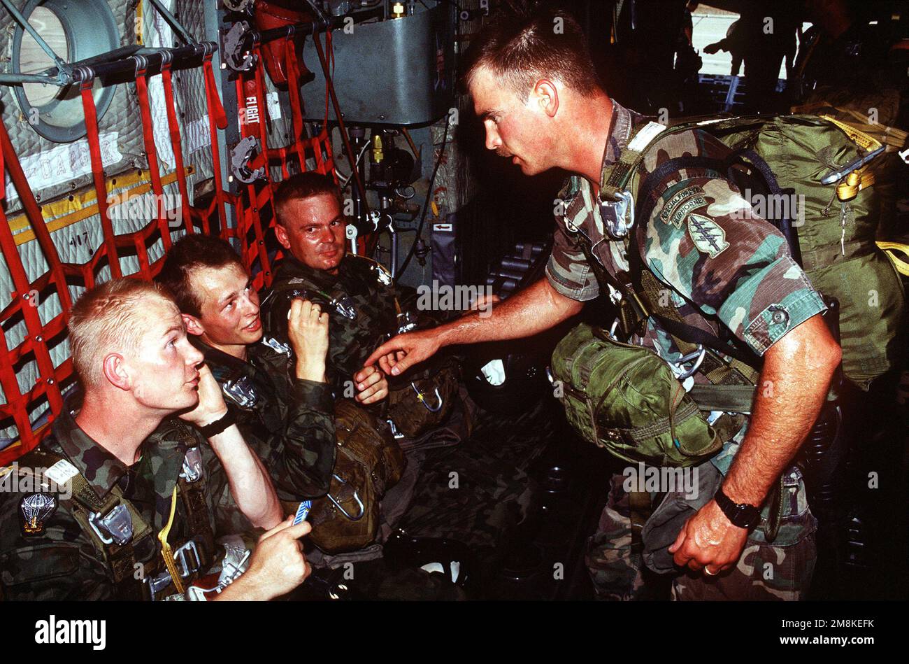 A US Army jumpmaster briefs and checks the Polish paratroopers prior to ...