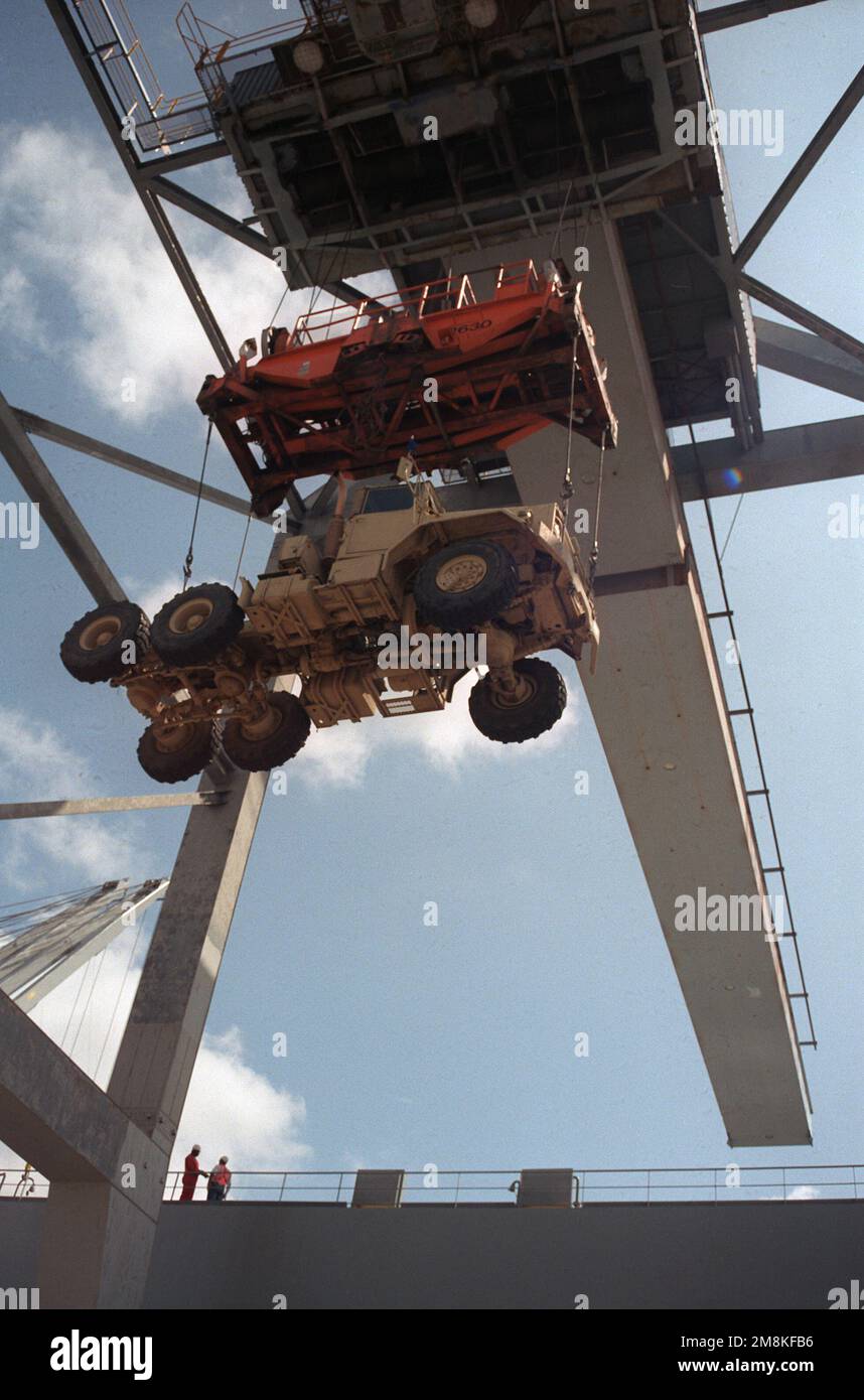 An M932 Tractor truck is being lifted by crane on board the US Naval ...