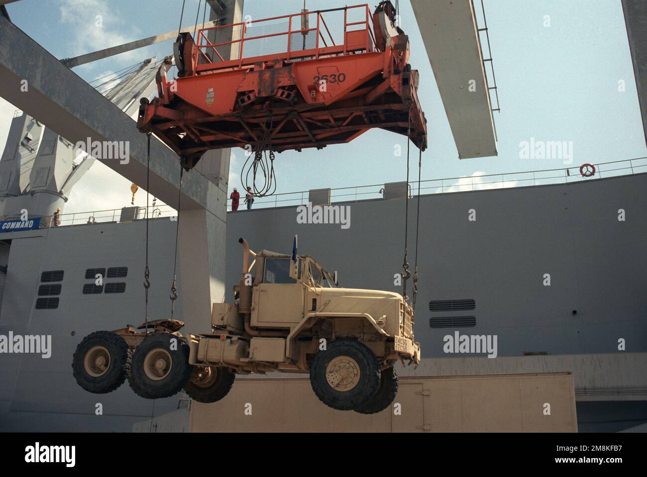View of an M932 tractor truck being lifted by on board the US Naval ...