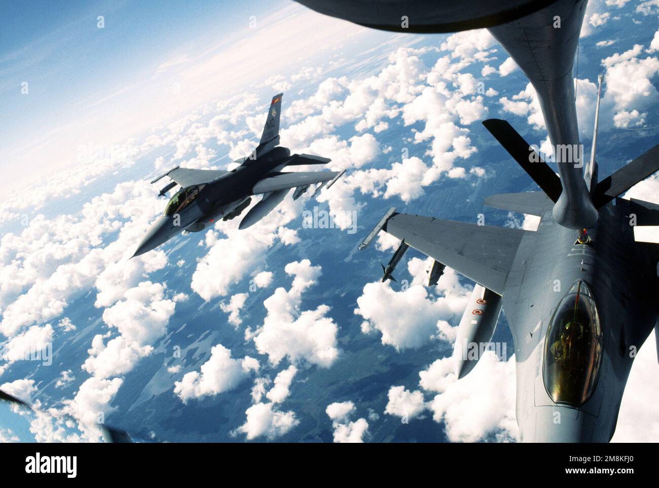 Above white clouds an F-16 "Fighting Falcon" from the 389th Fighter ...