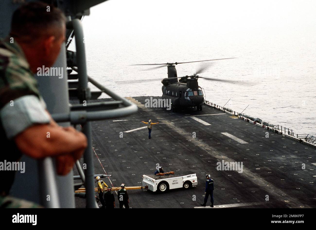 A US Army CH-47D Chinook helicopter lands on the flight deck for deck landing qualifications ...