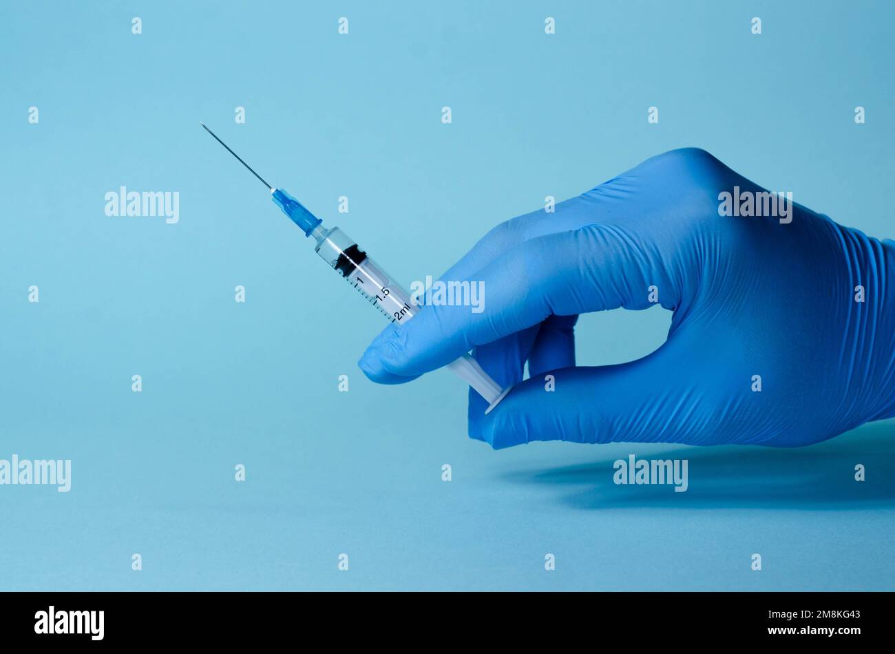 Doctor in blue latex gloves with syringe, close-up. Making a vaccine ...