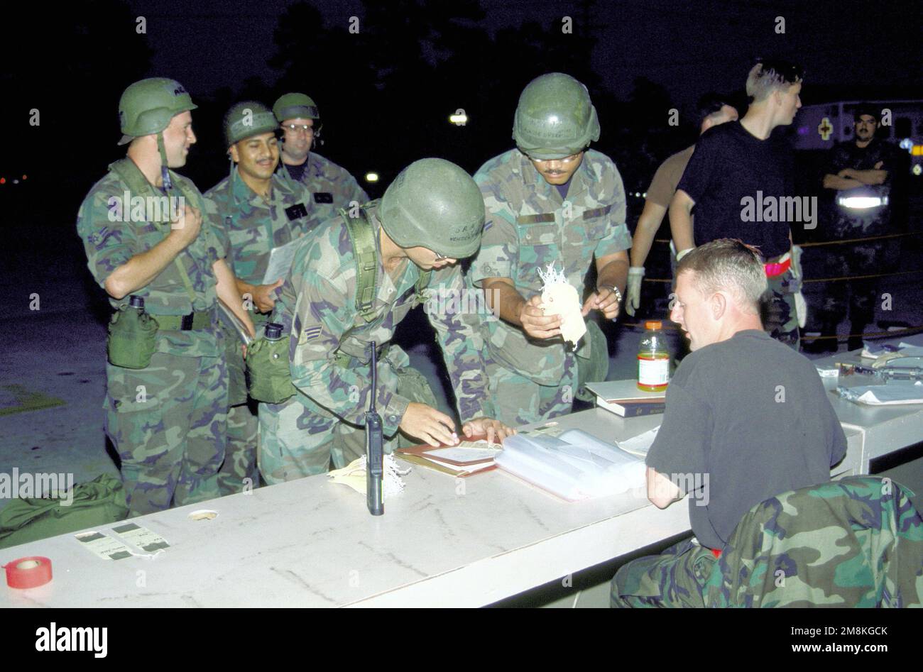 Personnel fill out baggage tags in the mobility processing line during ...