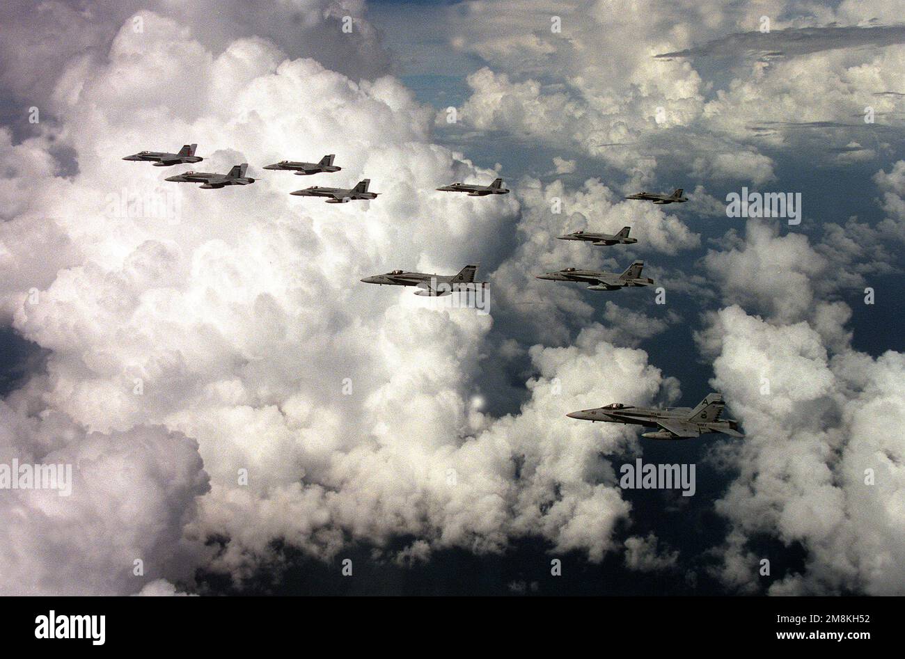An aerial left side view of a formation of ten (10) F/A-18 Hornet ...