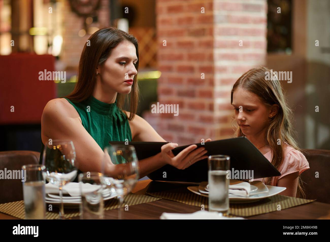 Mother giving menu to daughter and asking wjat she wants to eat Stock ...