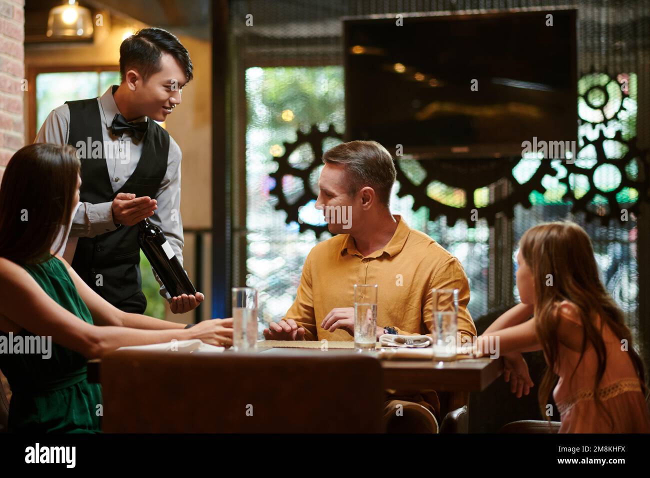 Fancy restaurant waiter showing customer bottle of good red wine Stock ...