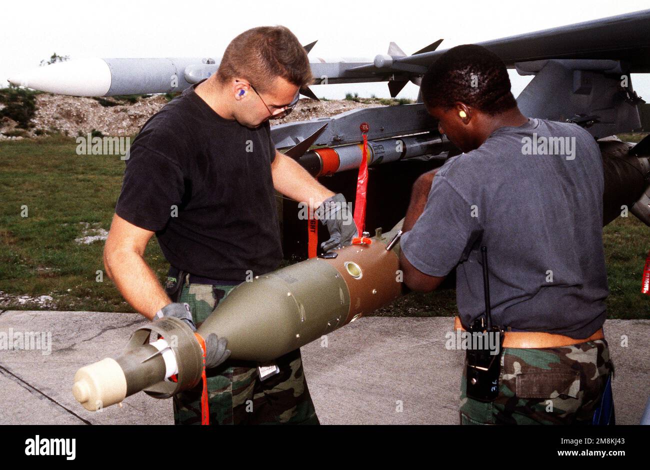 Weapon loaders load a HARM or High-speed Anti-Radiation Missile onto a ...