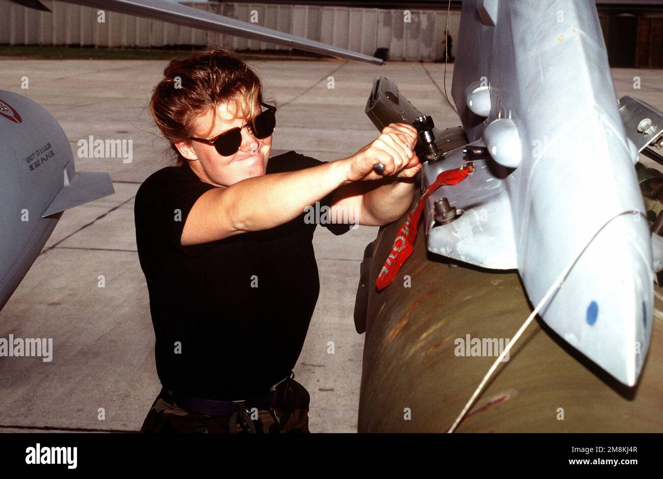 A female weapons loader load GBU-10 munitions onto a US Air Force F-16C ...
