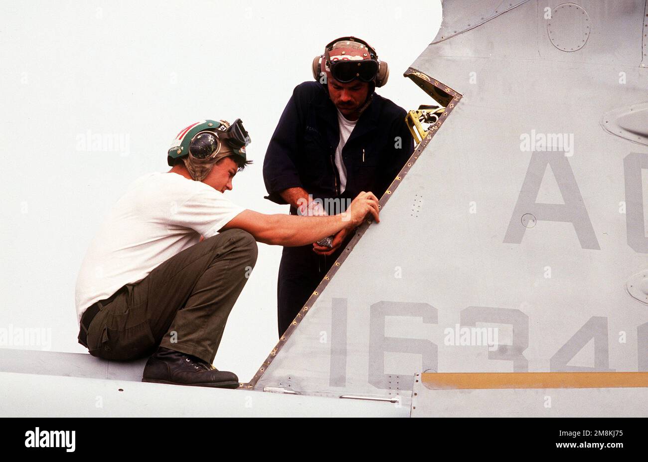 Two US Navy aircraft maintenance personnel perform a 56 day preventive ...