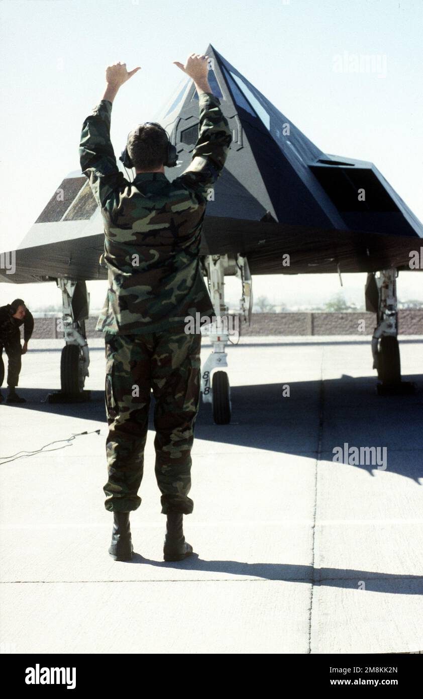 A crew chief signals to the pilot of an F-117A Nighthawk from the 49th ...