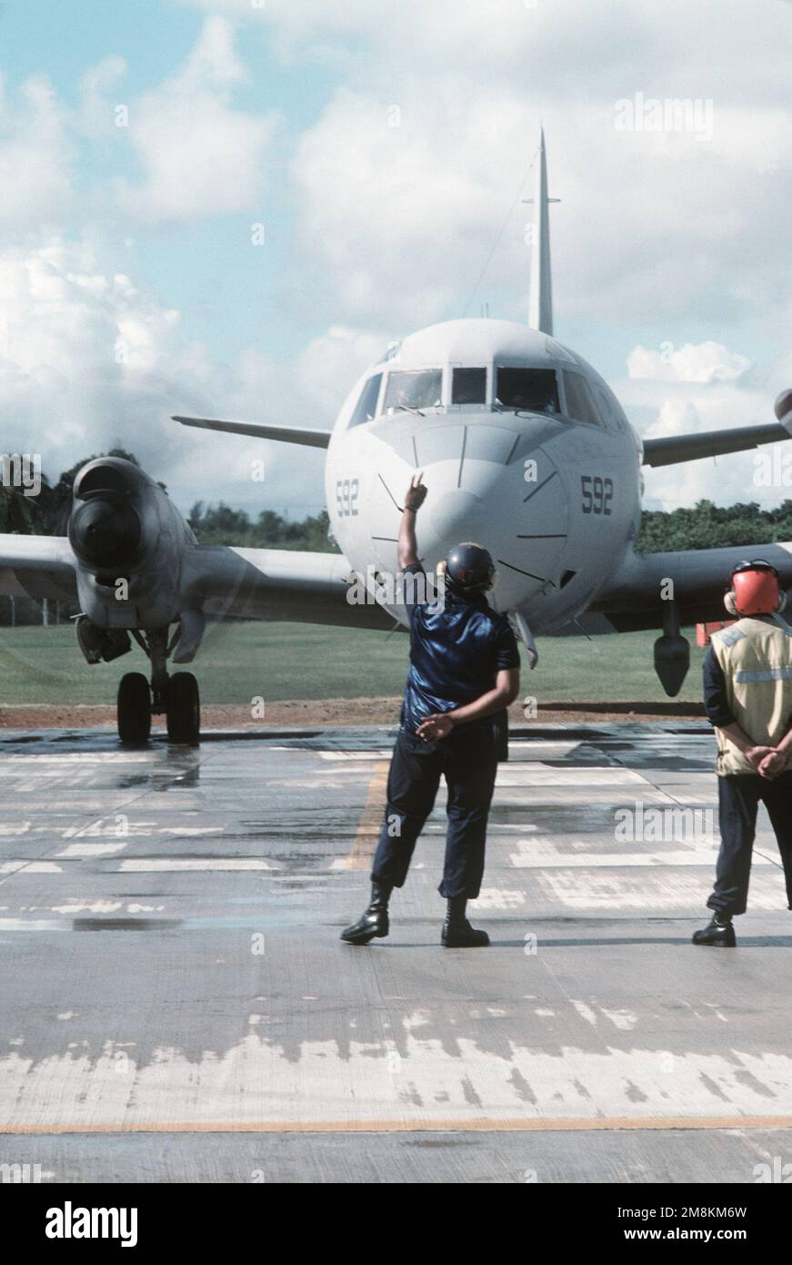 Plane captain AIRMAN Christopher Pyles signals to the pilot of a P-3C ...
