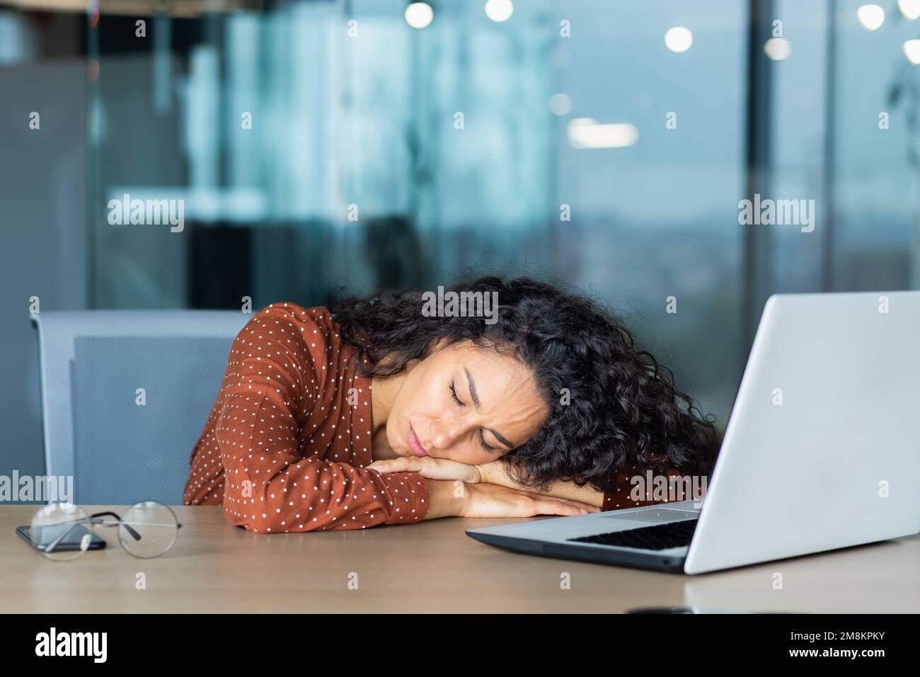 Beautiful tired hispanic woman sleeping on desk, close-up business ...