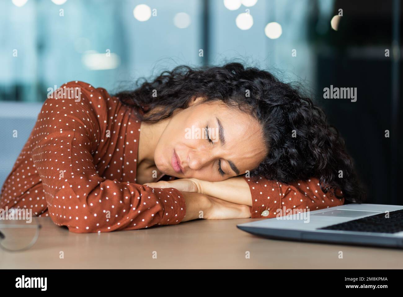 Beautiful tired hispanic woman sleeping on desk, close-up business ...