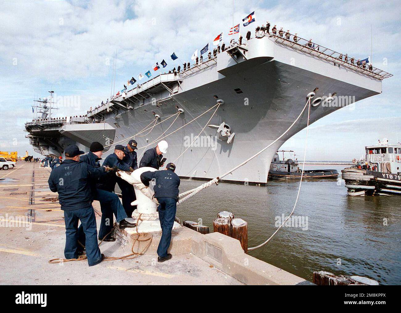 Sailors cast off mooring lines during sea and anchor detail for the ...