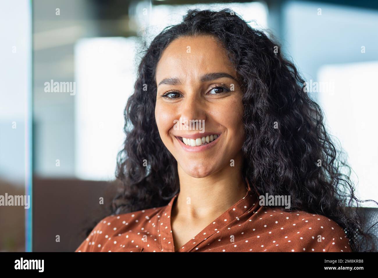 Close-up portrait of beautiful Latin American businesswoman smiling and ...