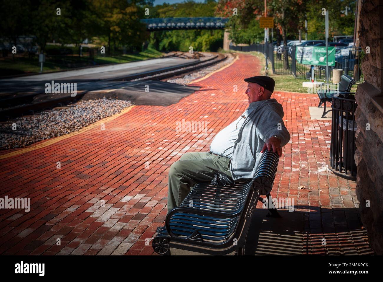 An elderly gentleman waiting on the next train with a smile on his face ...