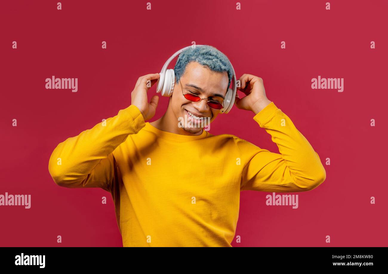 Positive american man listening music, enjoying dance with headphones ...