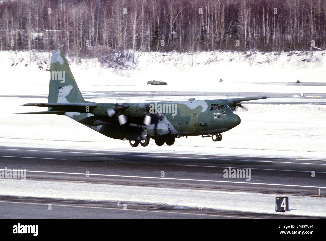 Kulis Air National Guard C-130 takes off from the snow-cleared runway ...