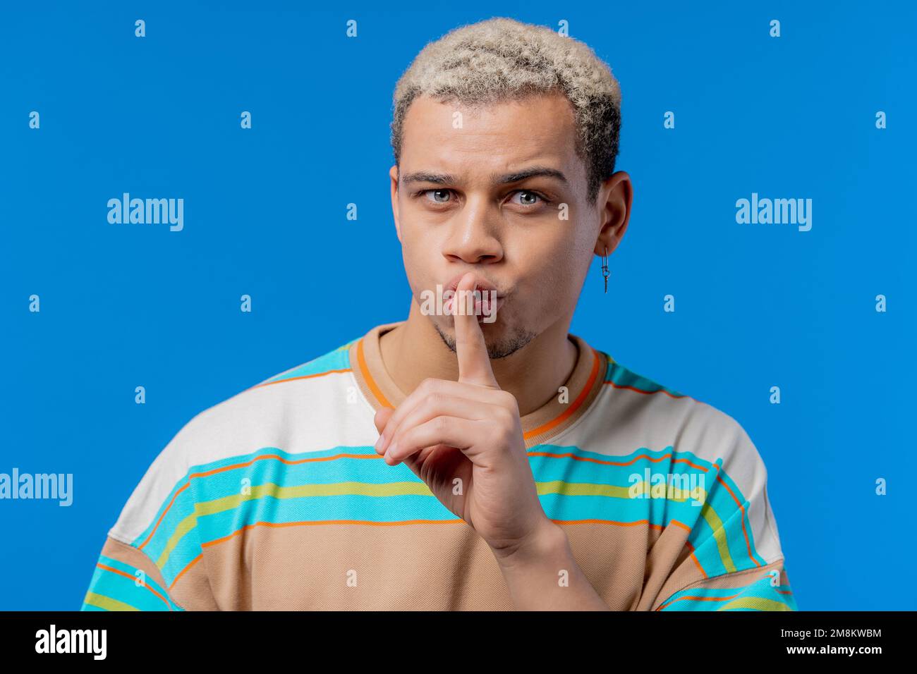 Handsome man with gesture of shhh, secret, silence, conspiracy, gossip ...