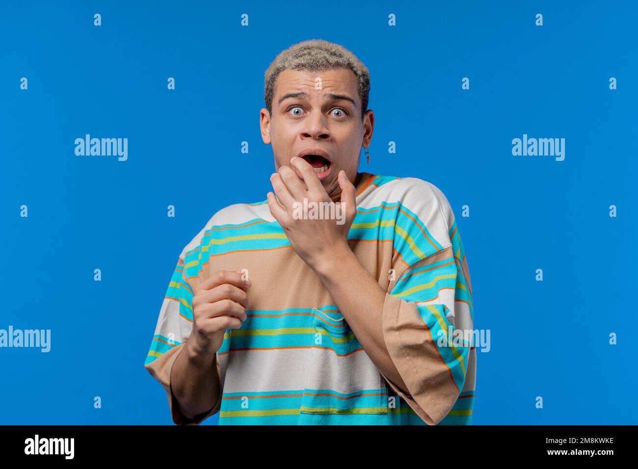 Frightened shocked man afraid of something and looks into camera with ...