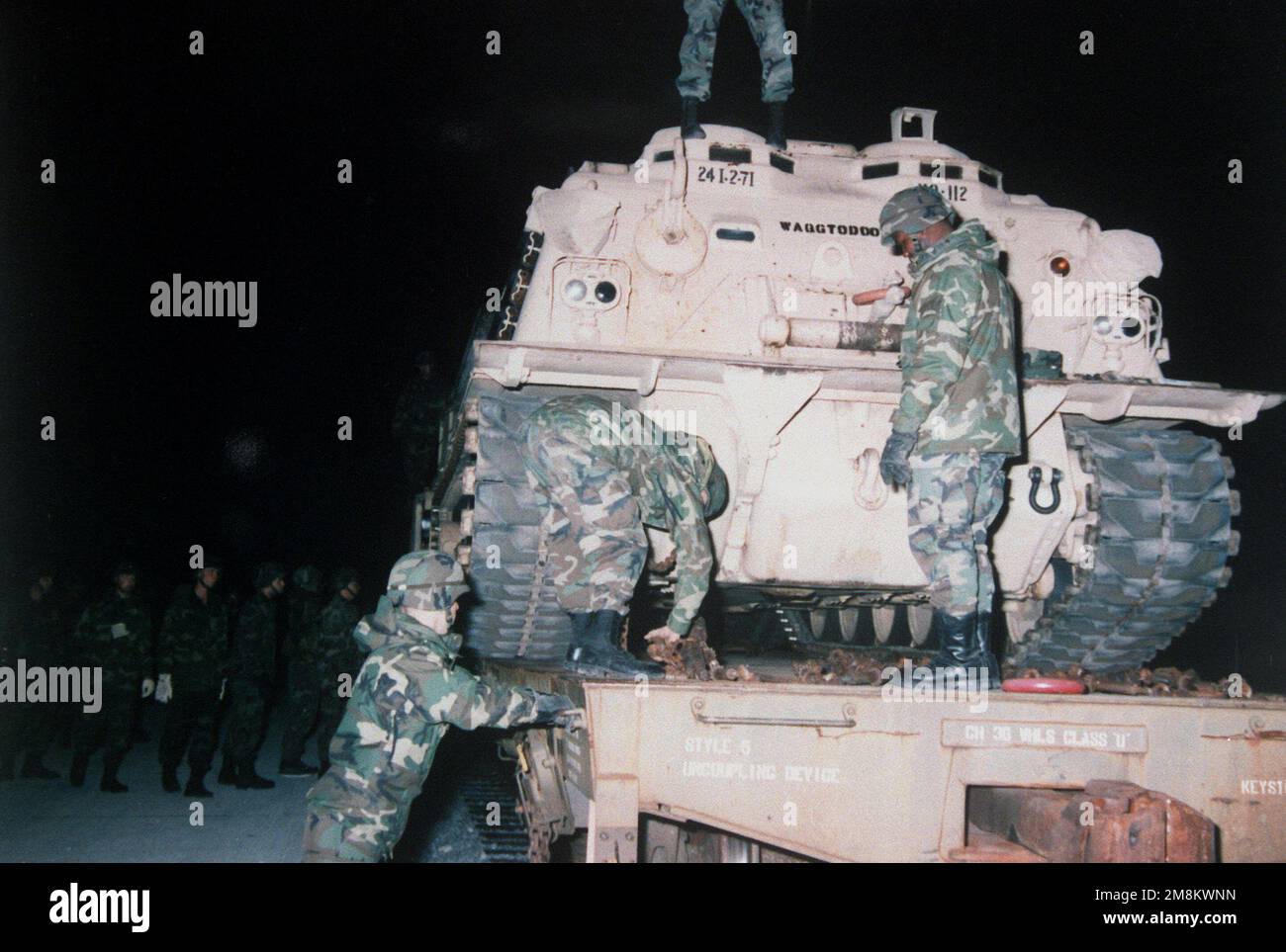 An M88A1 armored recovery vehicle is secured to a railcar at the rail ...