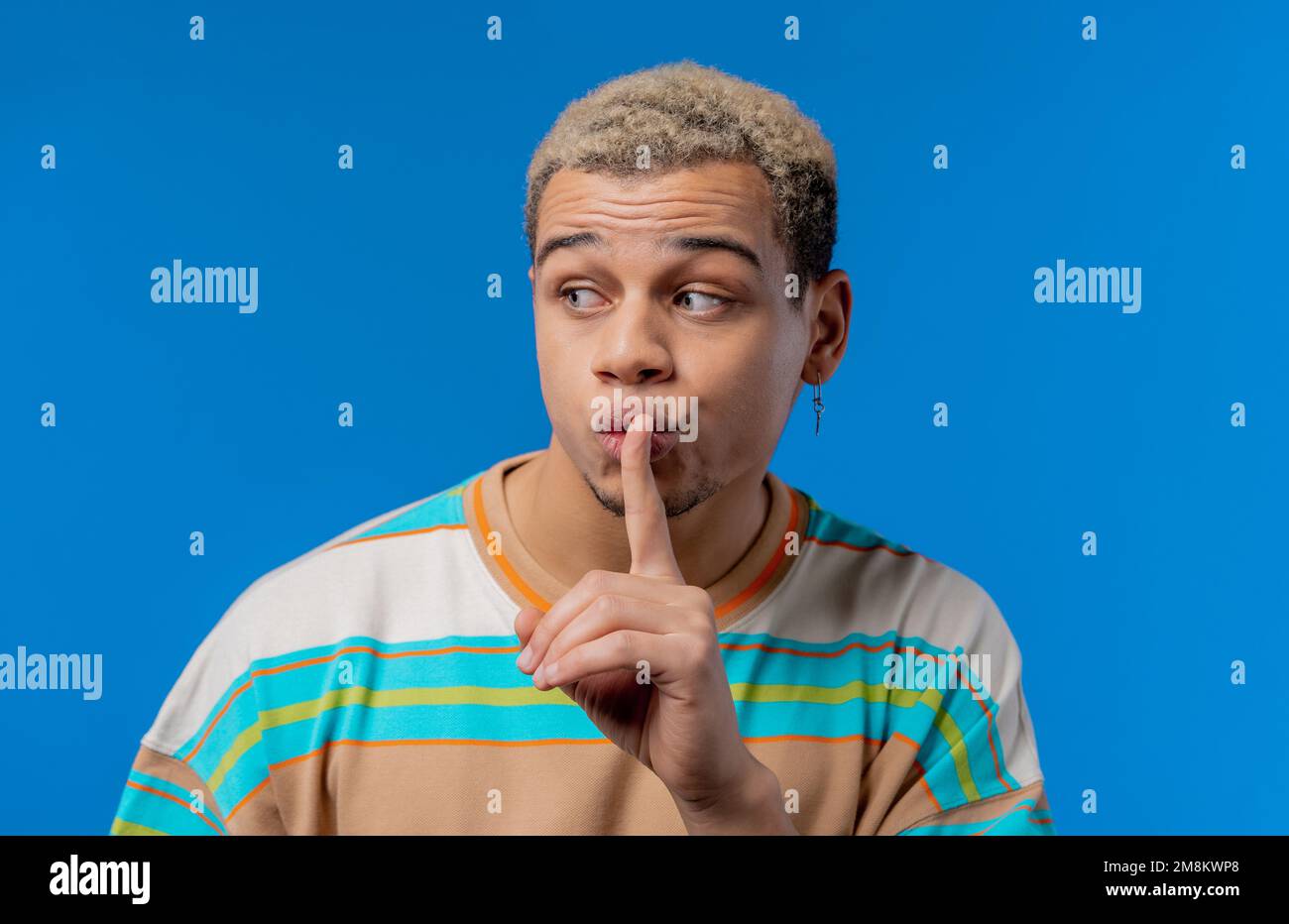 Handsome man with gesture of shhh, secret, silence, conspiracy, gossip ...