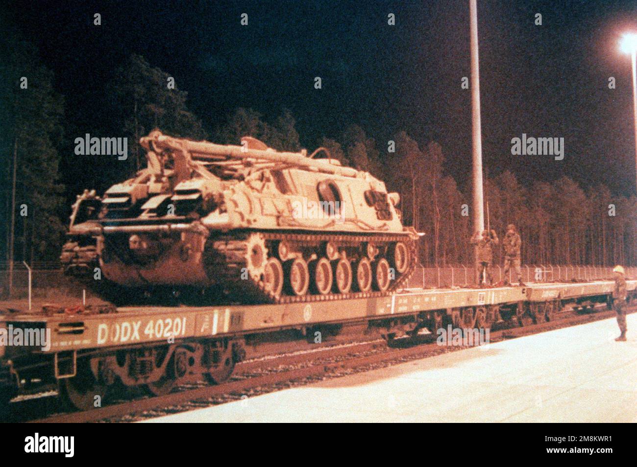 An M88A1 armored recovery vehicle loaded on a railcar at the well ...