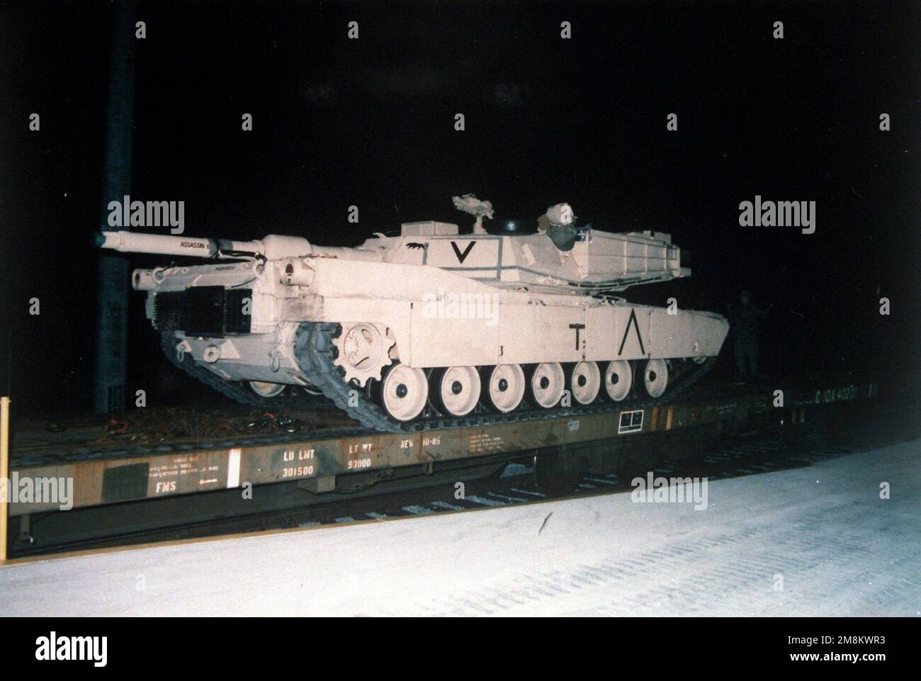 An M-1 Abrams Tank is loaded onto a railcar at the rail marshaling area ...