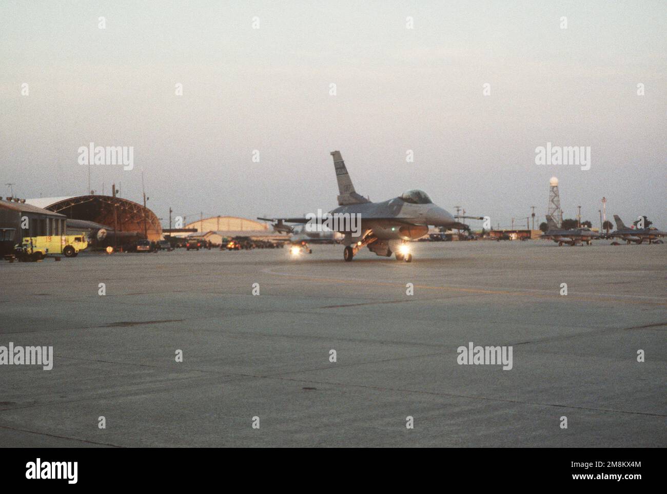 Two F-16 Fighting Falcons, with their landing lights on, scramble for ...