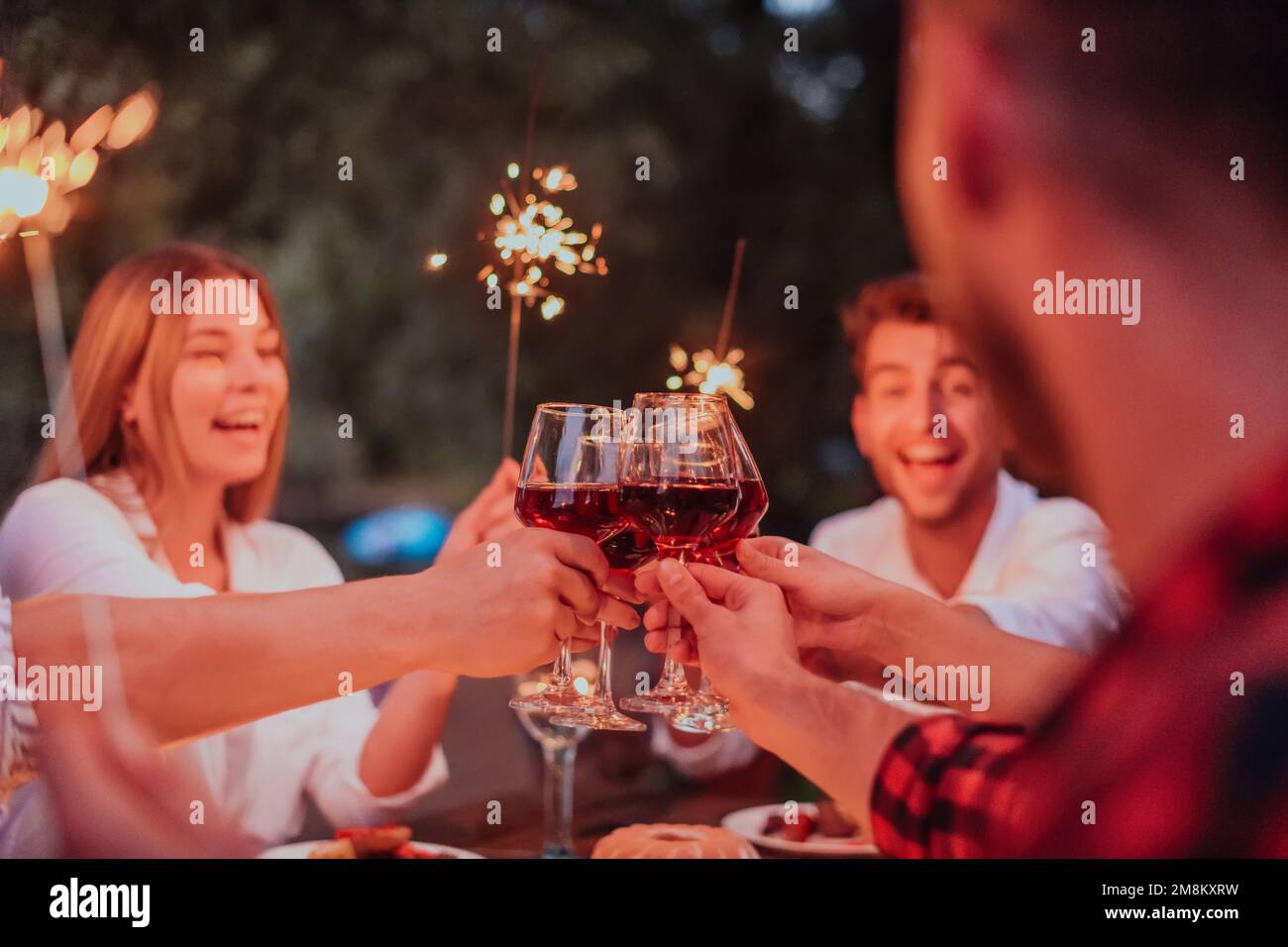Group of happy friends celebrating holiday vacation using sprinklers ...