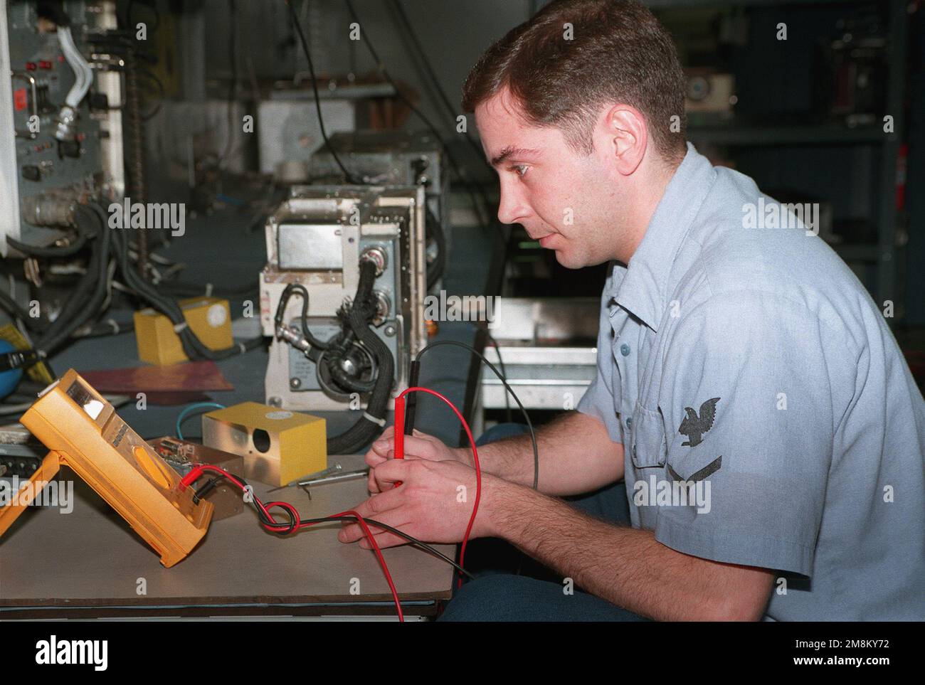 Aviation Electrician Third Class (AE3) Robert Pierce is shown trouble shooting a circuit card on ...