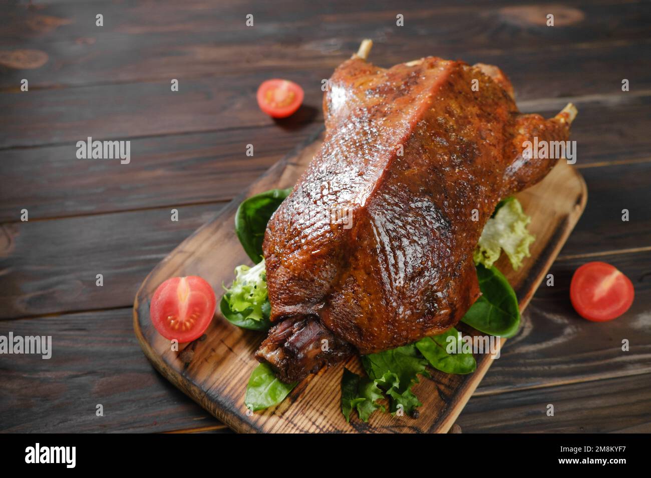 Whole roast duck and vegetables on a dark wooden board. horizontal view ...