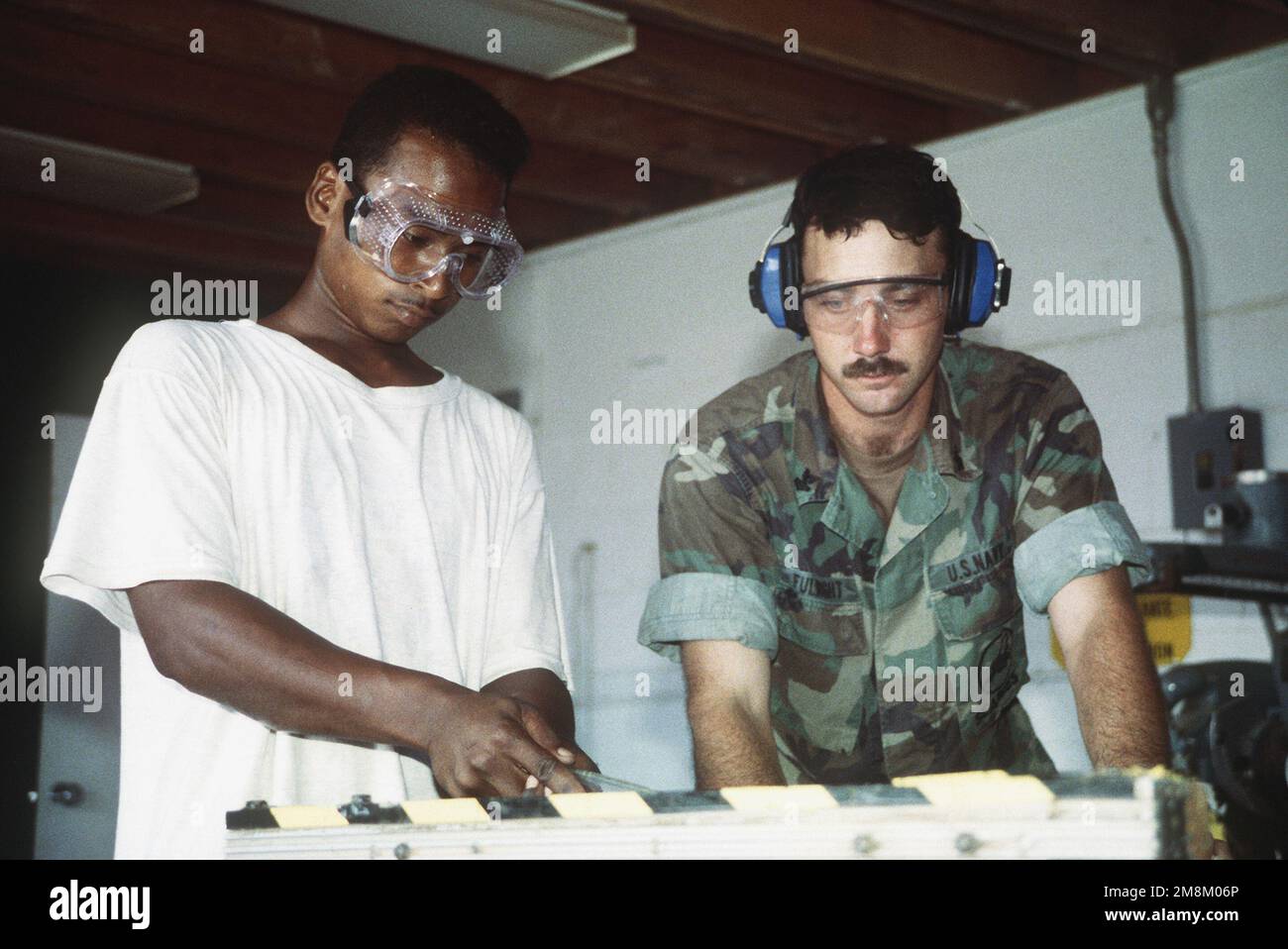 Equipment Operator Second Class (EO2) Larry Fulbright instructs one of ...