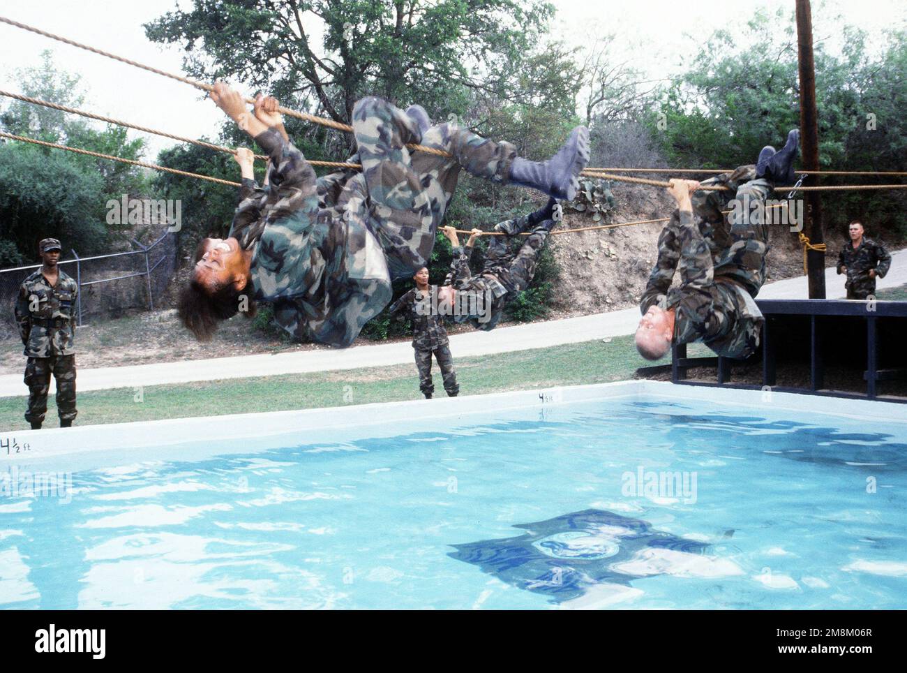 Basic Trainees cross water obstacle during confidence course training ...