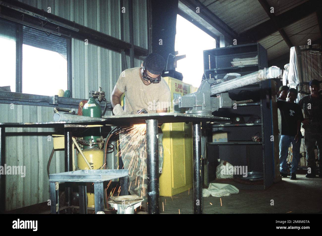 Steelworker Second Class (SW2) Frank Luevanos uses a cutting torch to ...