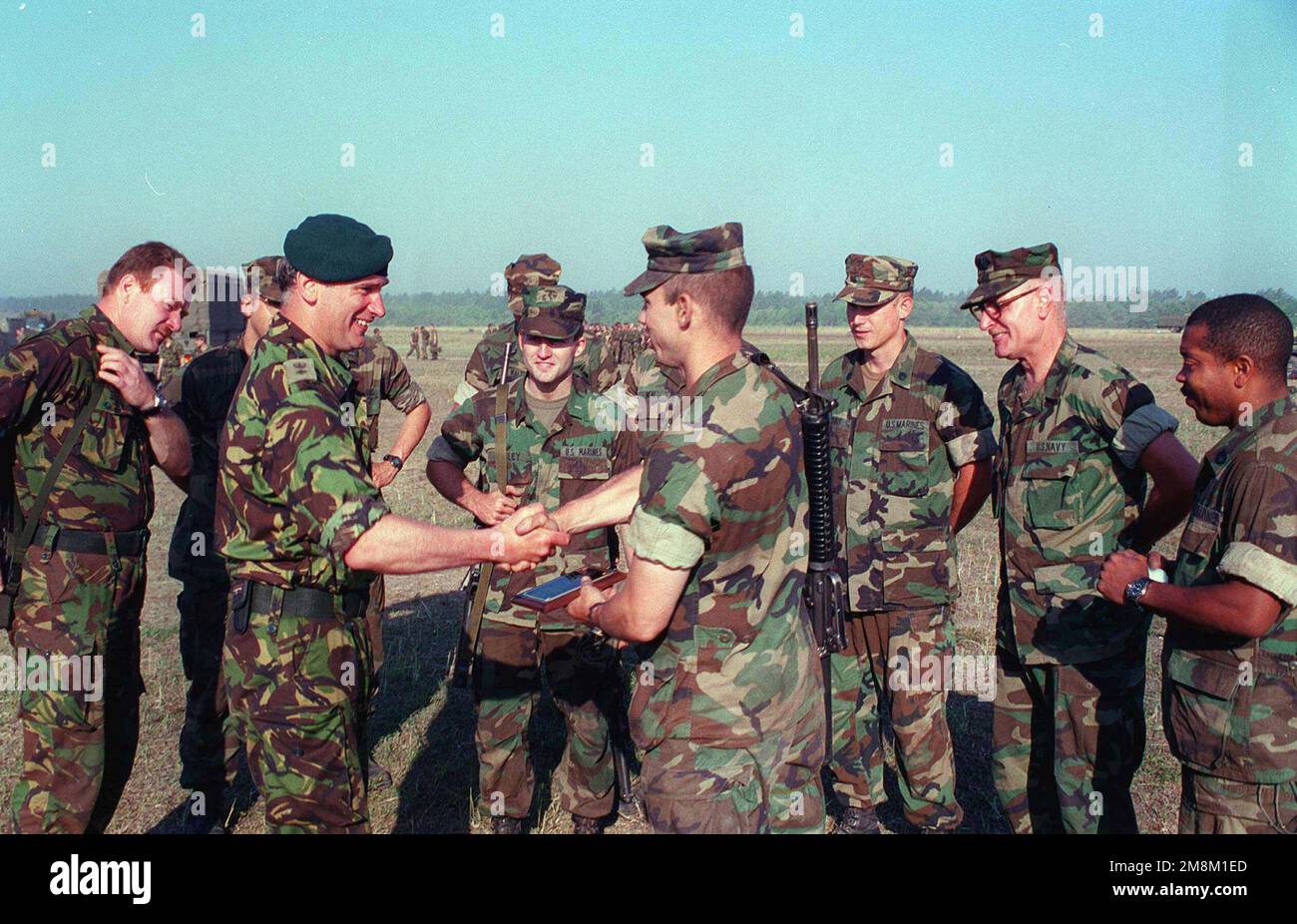 Tokens of appreciation are exchanged between the (left) battalion ...