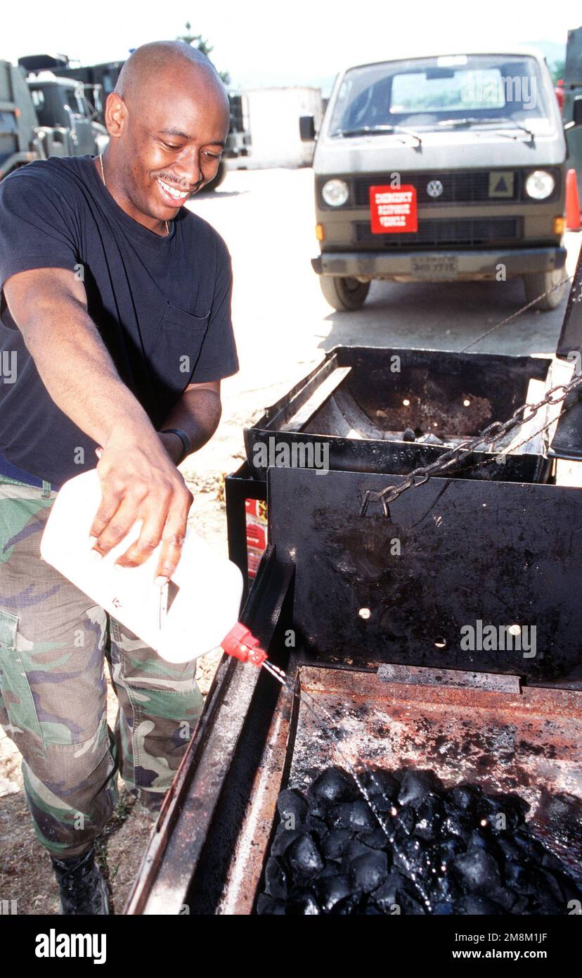 A member of the 4100th Operation Support Group puts charcoal lighter ...