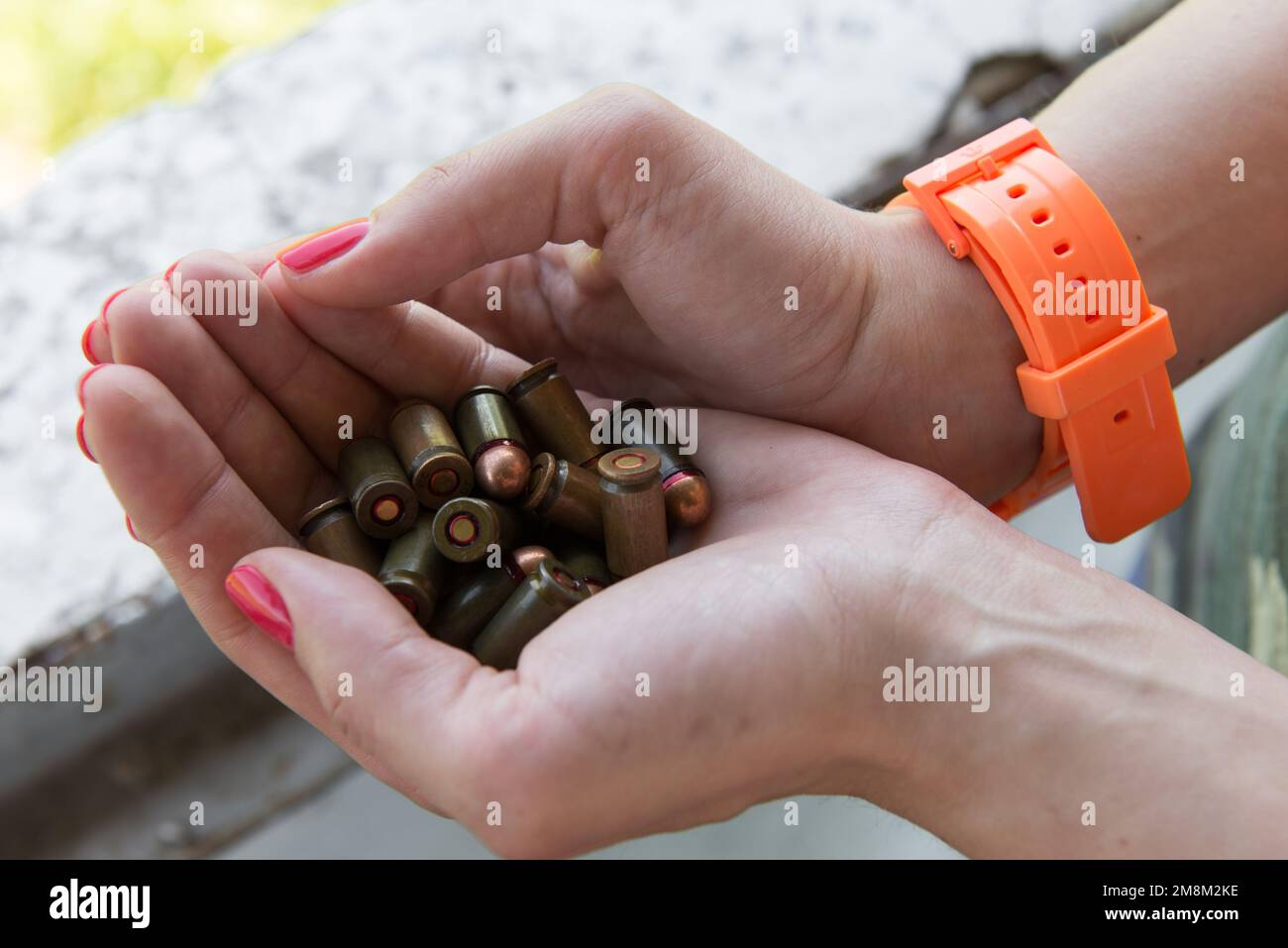 holding bullets for a rifle or pistol in a woman hand before shooting ...
