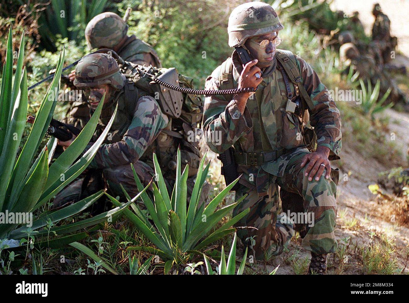 A US Marine Corps platoon leader and his radioman take cover along the ...