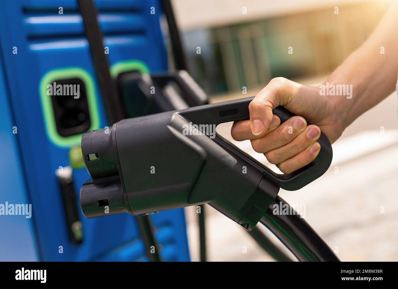 woman holding a DC - CCS type 2 EV charging connector at EV charging ...