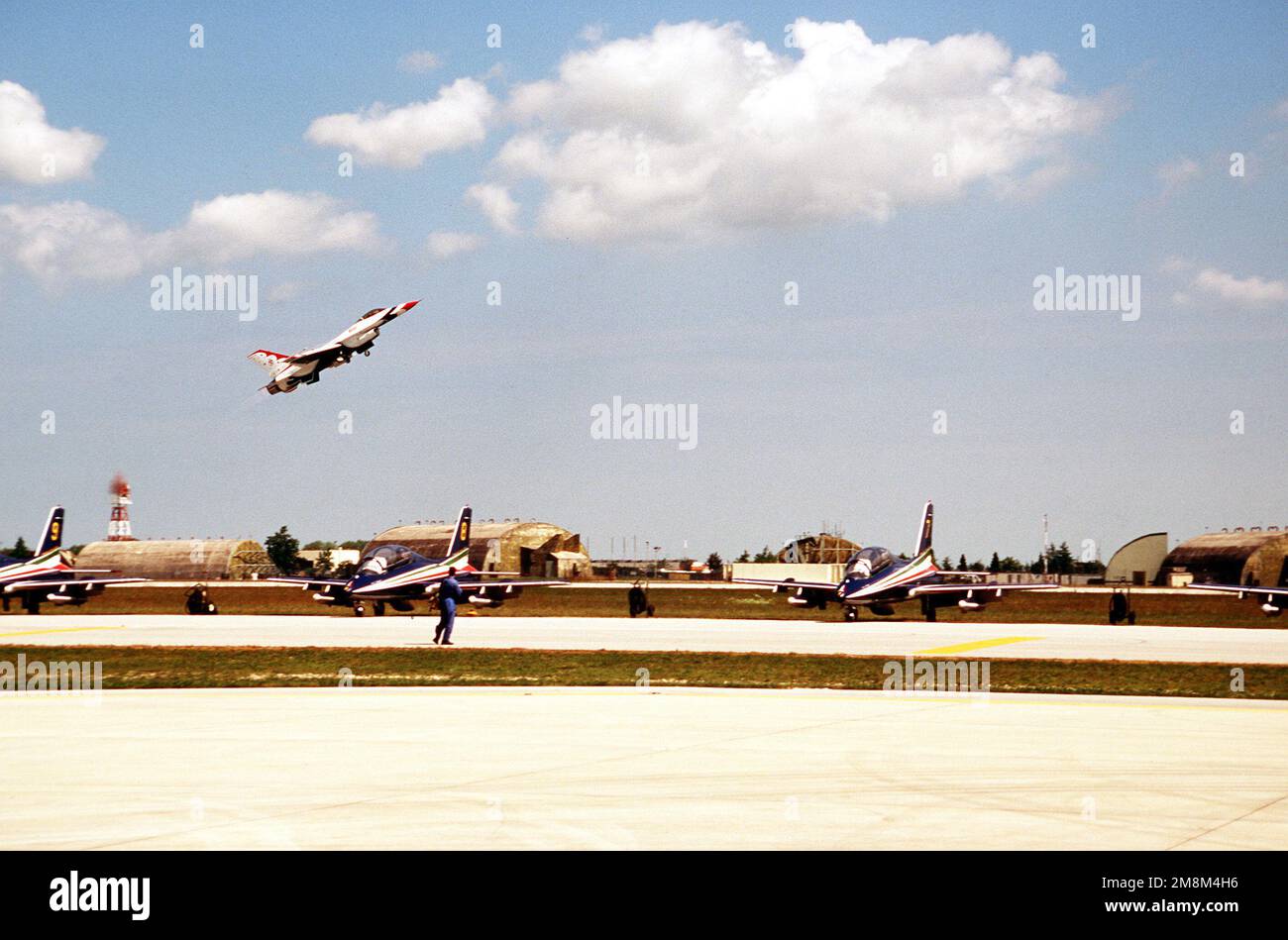 A USAF Thunderbird F-16 Fighting Falcon takes off above a line of ...