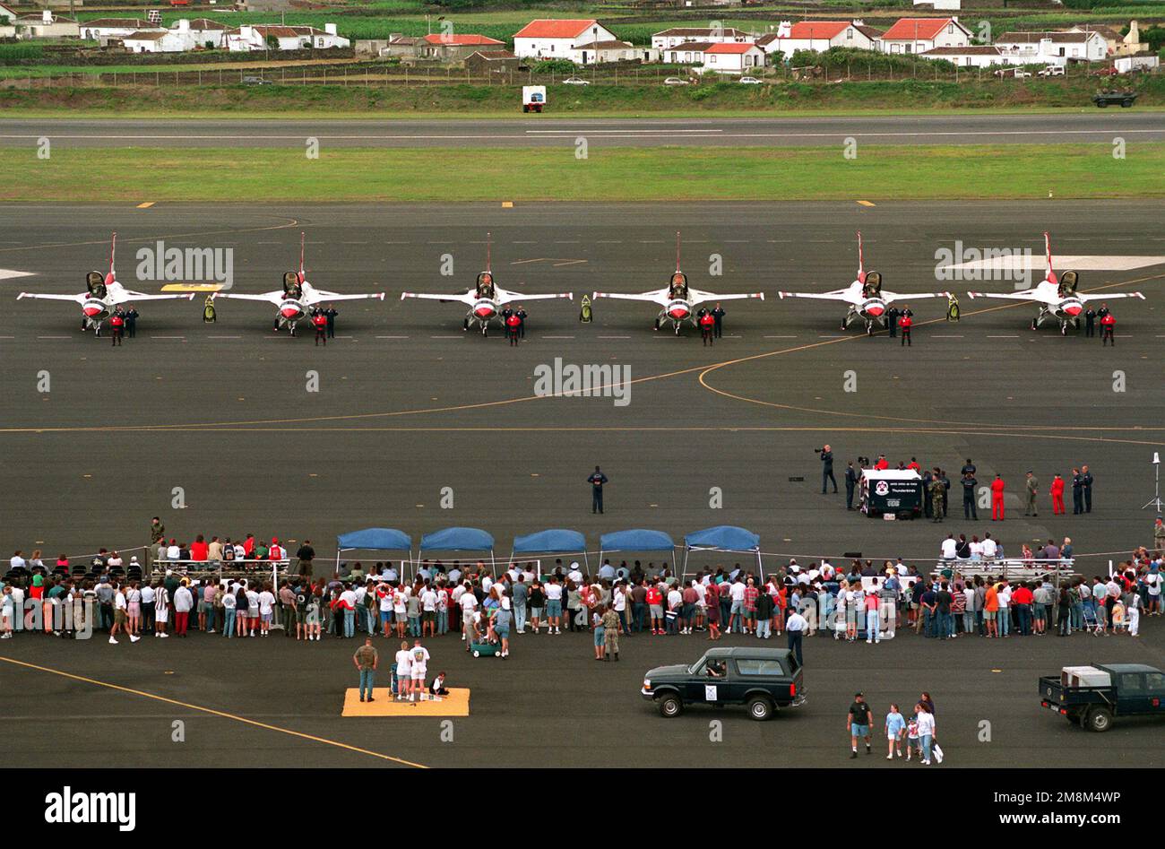 With the crowd watching, the 1996 USAF Thunderbirds Team waits on the runway in their F-16 ...