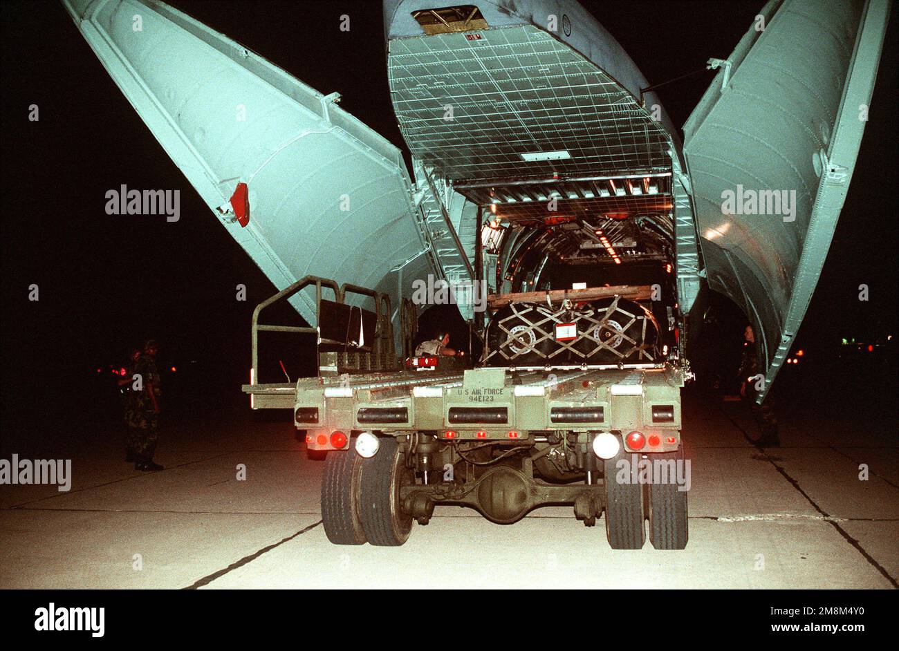 A flat-bed truck is positioned at the rear of an opened C-141B ...