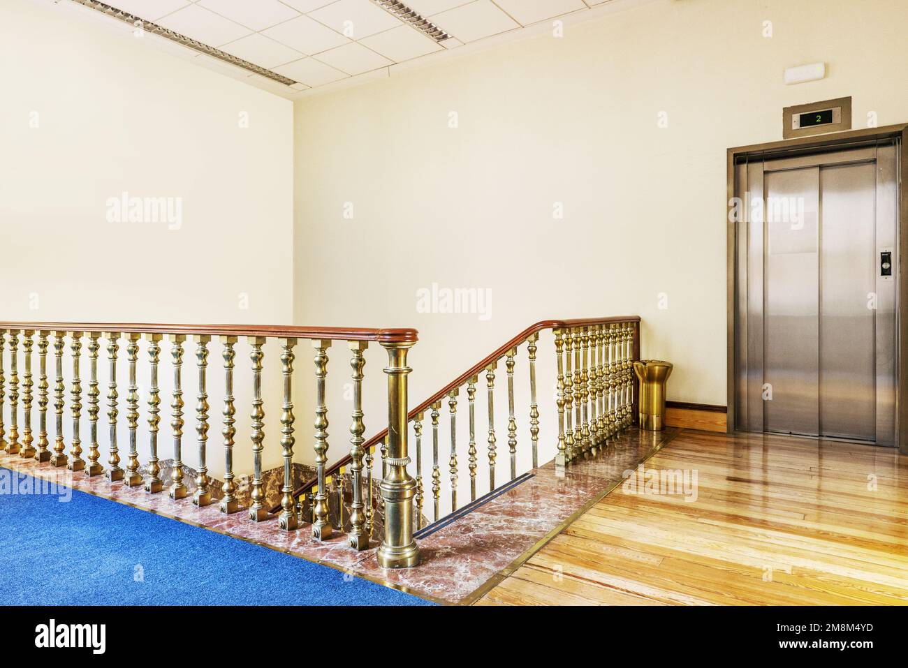 Elevator and stair area of a vintage building with hardwood floors and ...