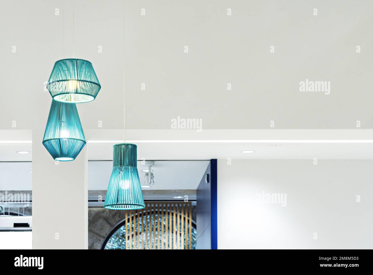 Decorative indoor lamps made of blue rope hanging in a spacious room ...