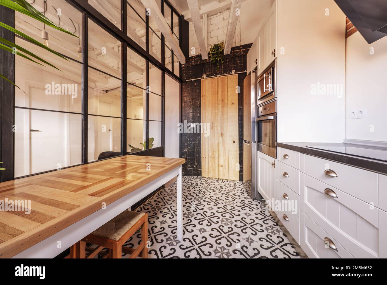 Furnished kitchen of a vacation rental loft with a French-style black ...