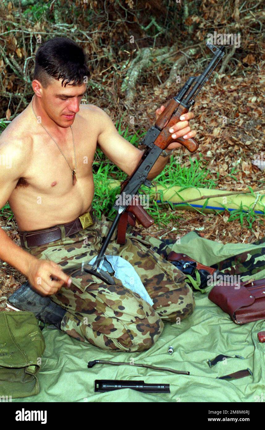 A Romanian Soldier, not wearing his uniform shirt, cleans and ...