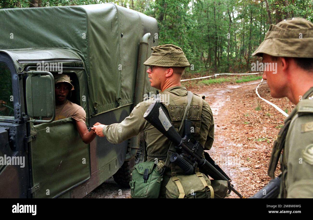 Two Canadian Army soldiers check the identification of the personnel ...