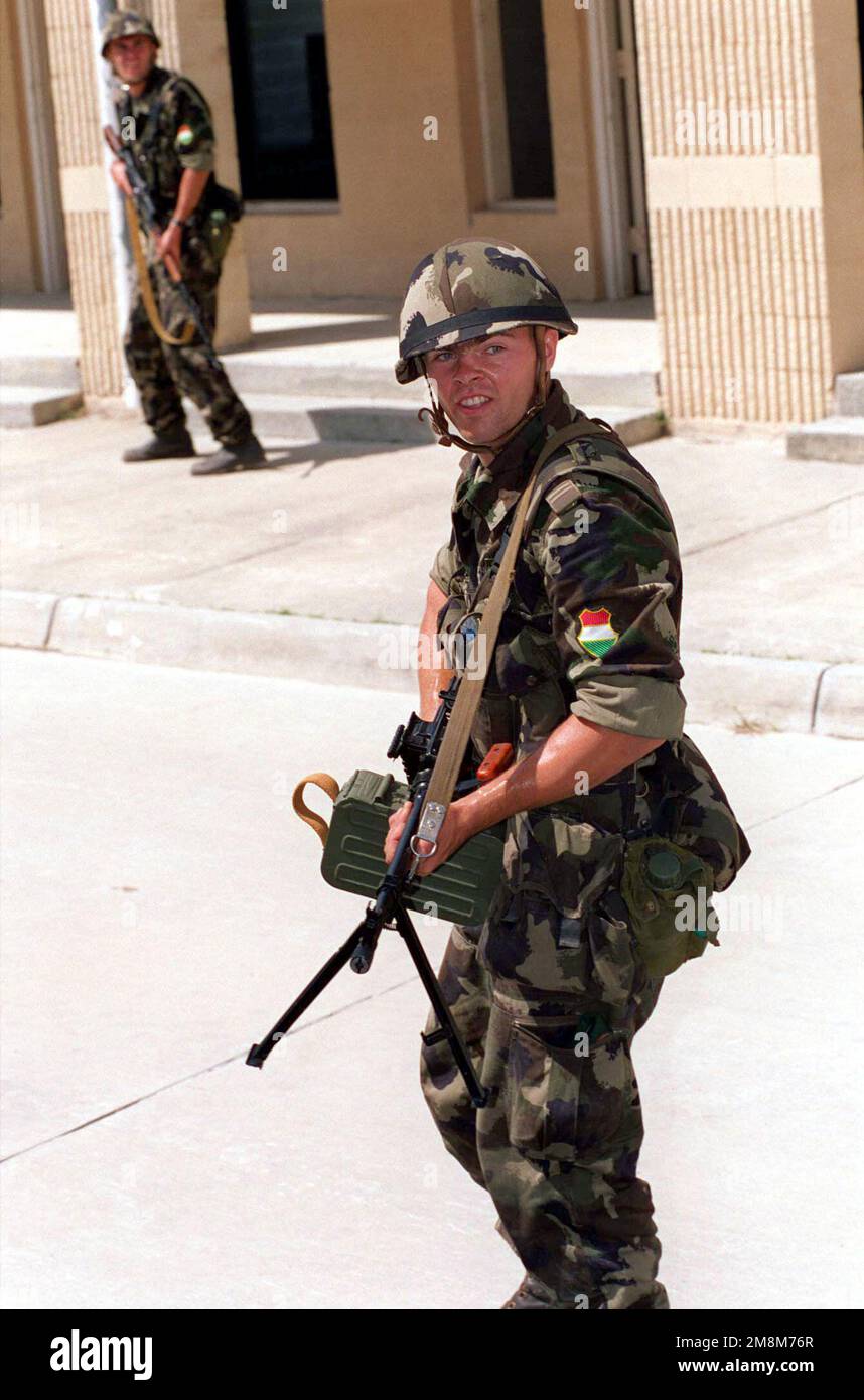 A pair of Hungarian soldiers armed with machine guns patrol the streets ...